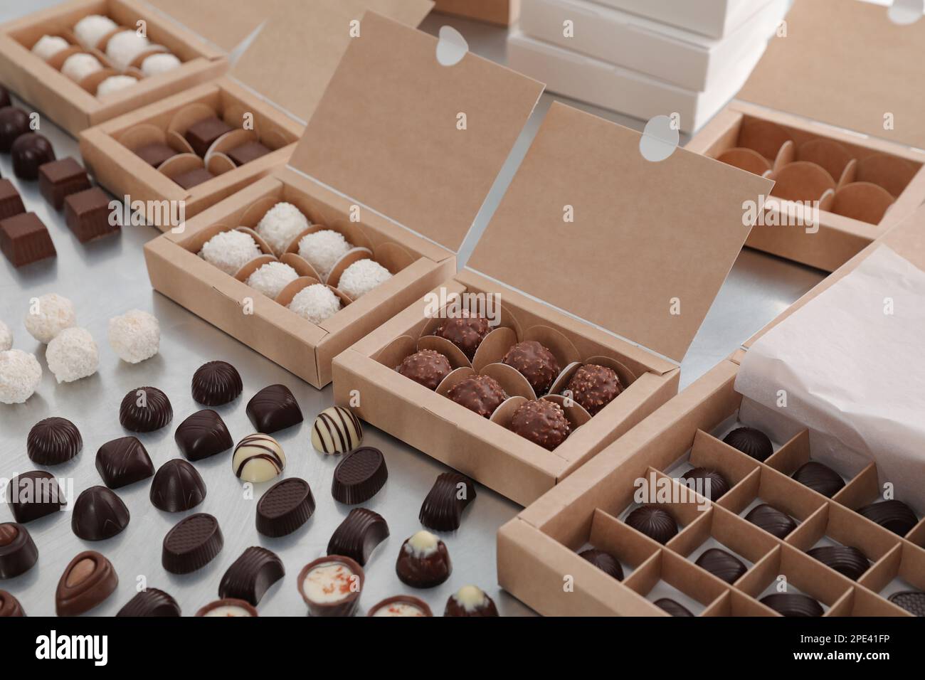 Different delicious chocolate candies and boxes on white table ...