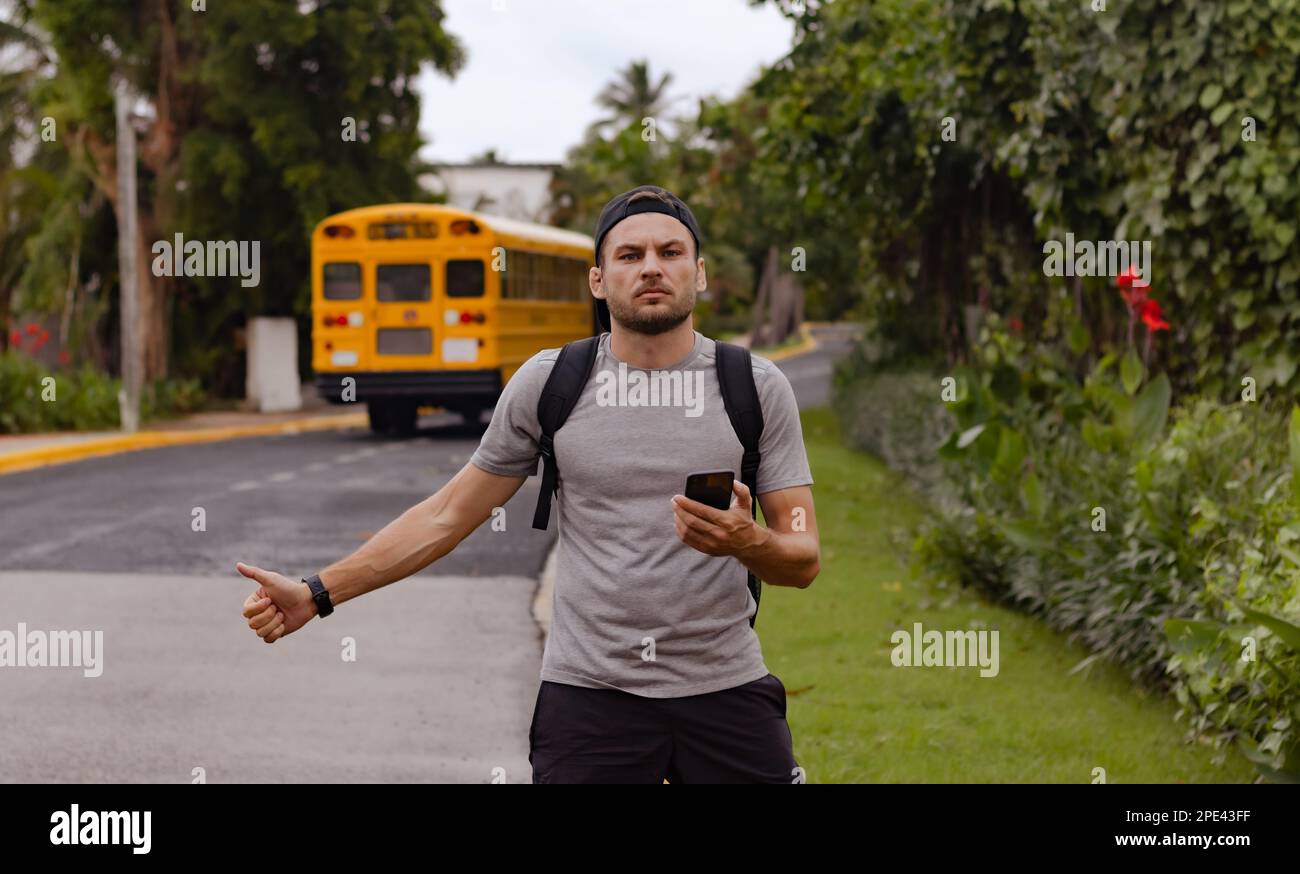Young adult man hitchhiking in Dominican Republic Stock Photo - Alamy