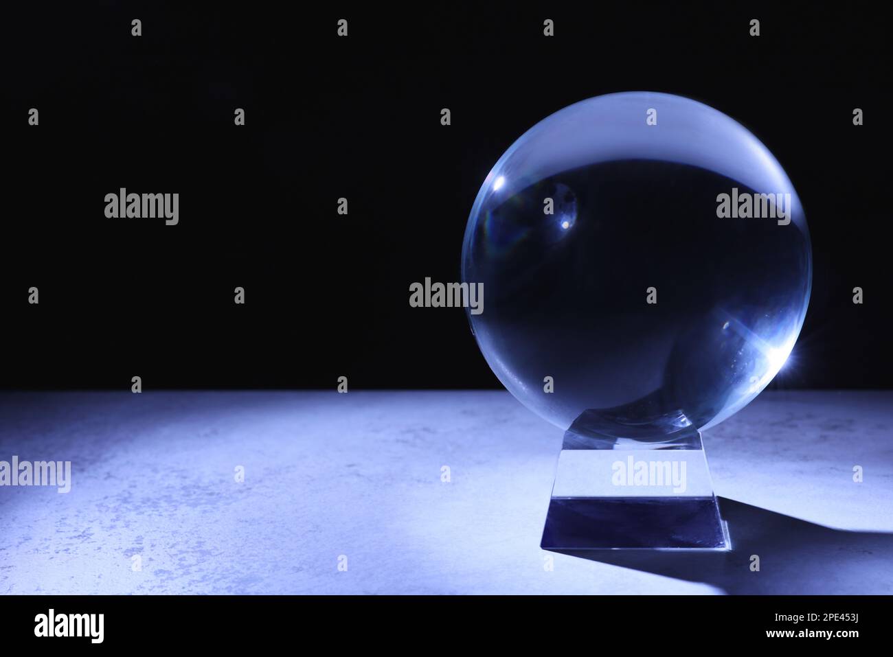 Crystal prediction ball on table in darkness, space for text. Fortune ...