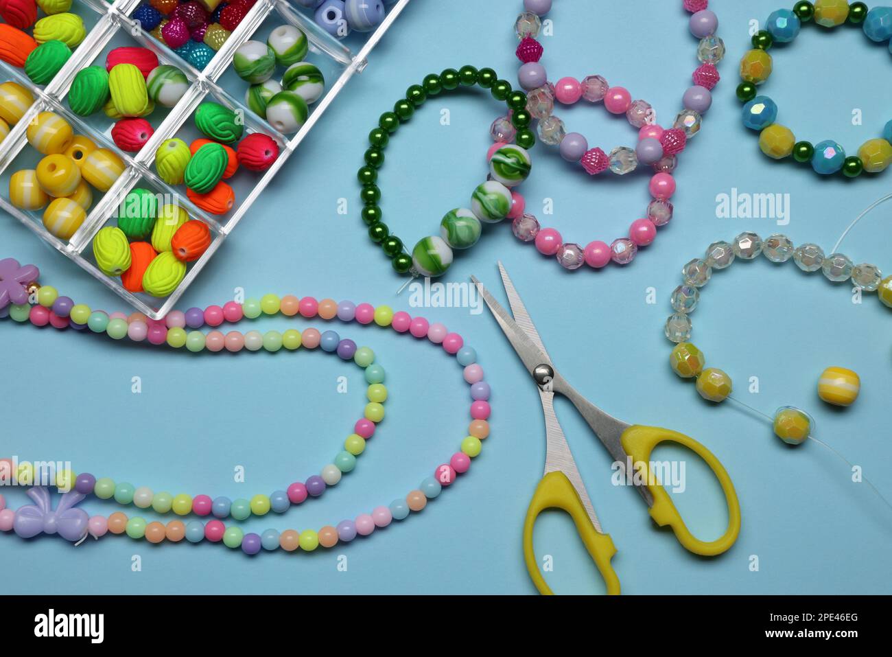Flat lay composition with different colorful beads on light blue ...