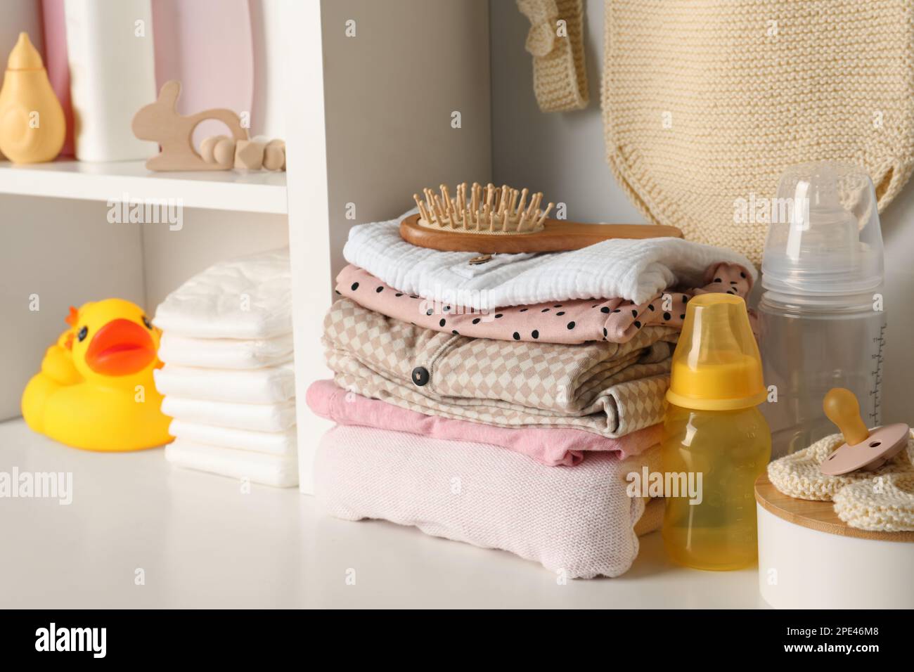 Baby clothes, toy and accessories on white rack Stock Photo - Alamy