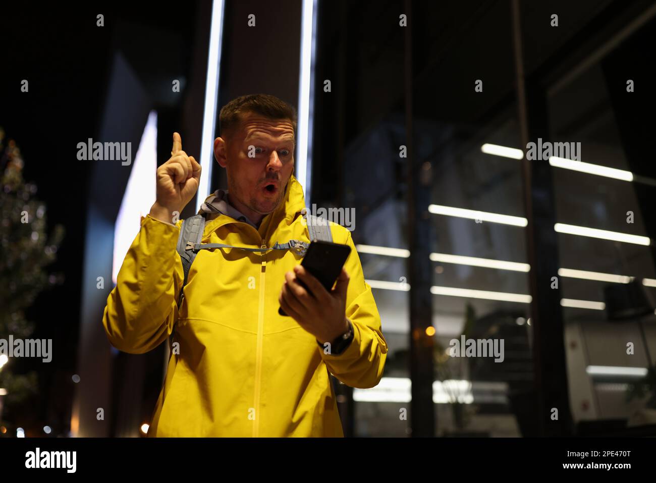 Inspired man with surprised face showing index finger up gesture while ...