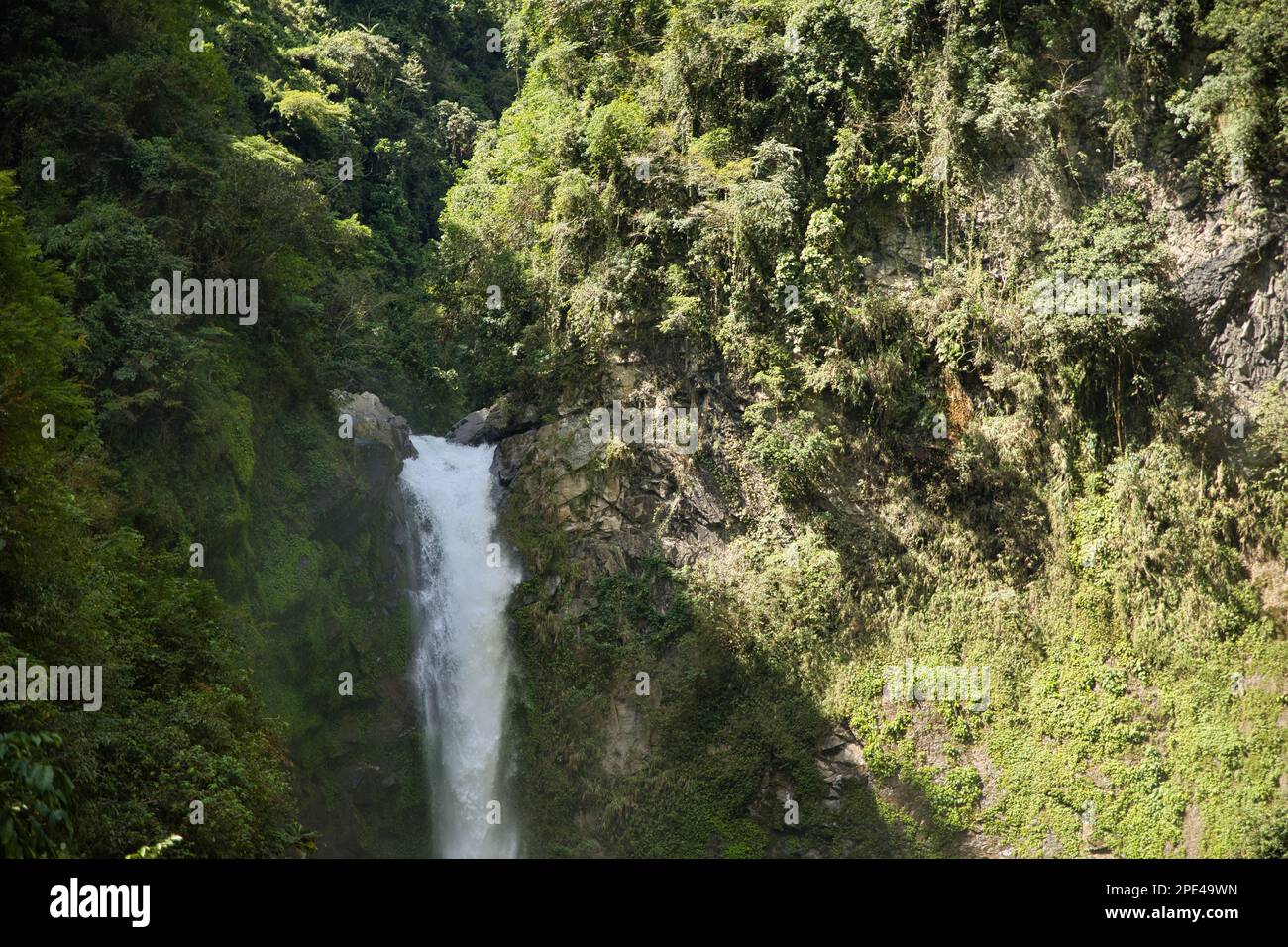 An imposing waterfall in an enclosed valley in Banaue in the ...