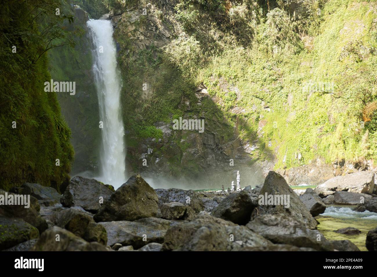 An imposing waterfall in an enclosed valley in Banaue in the ...