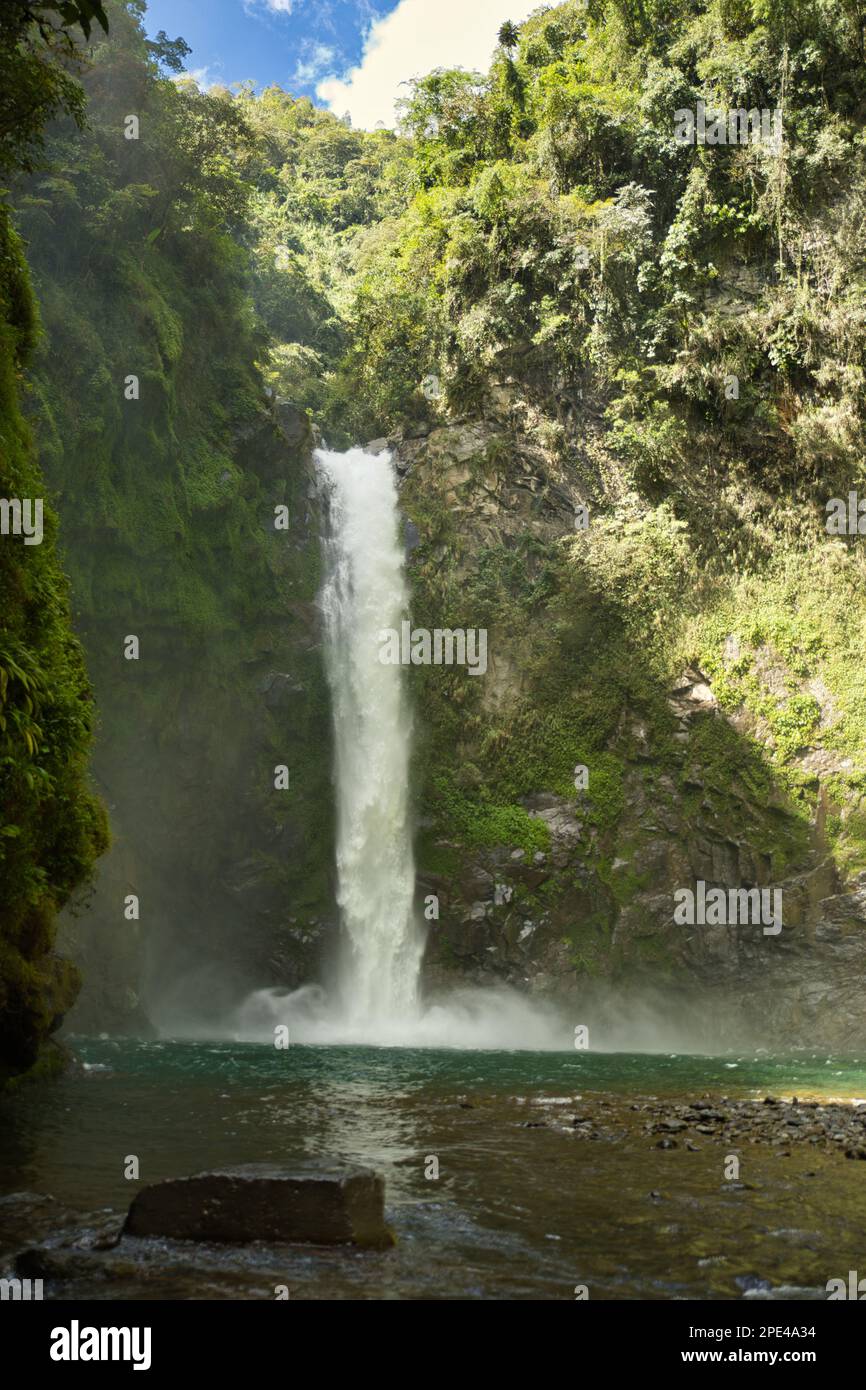 An imposing waterfall in an enclosed valley in Banaue in the ...