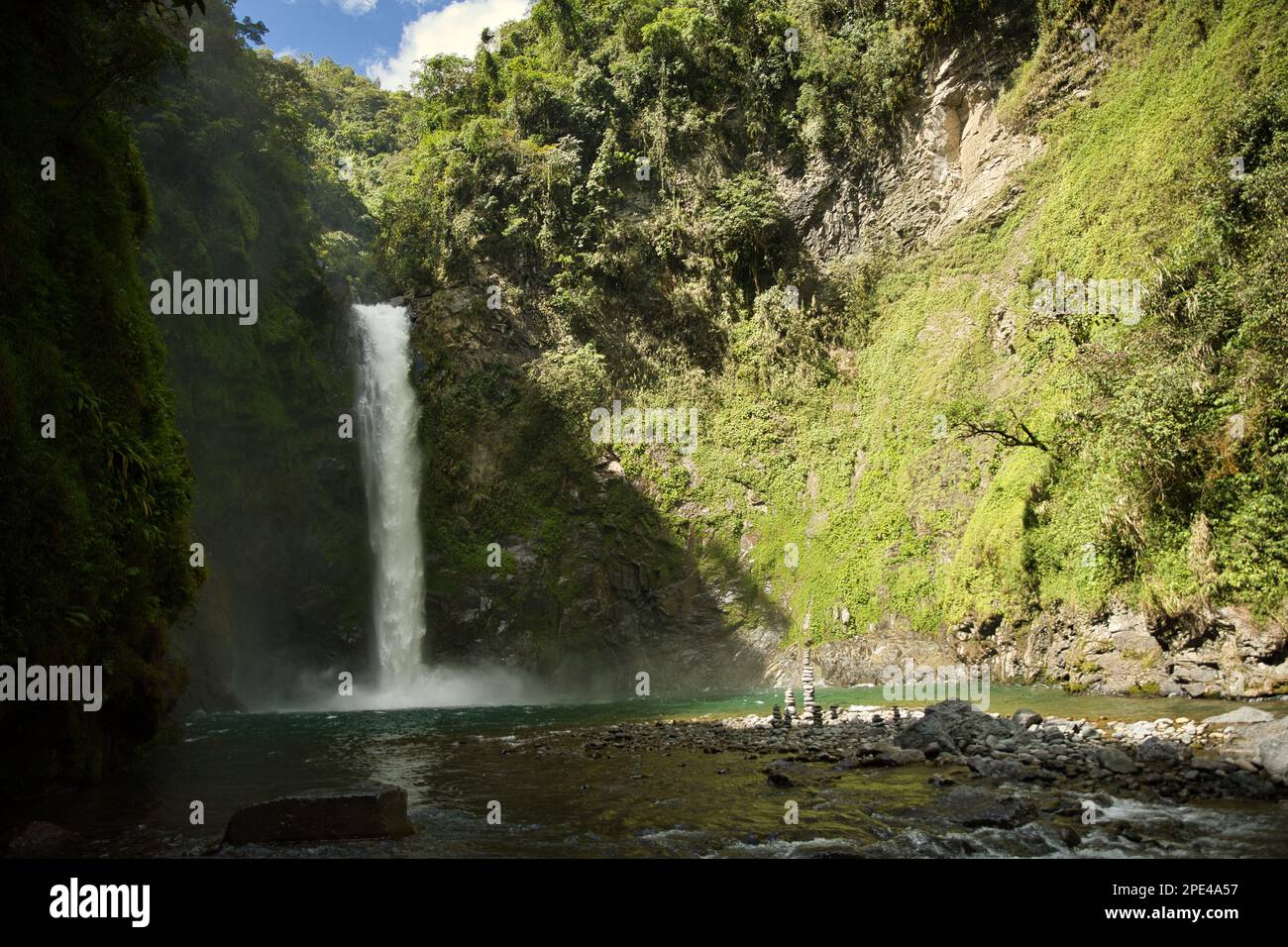 An imposing waterfall in an enclosed valley in Banaue in the ...