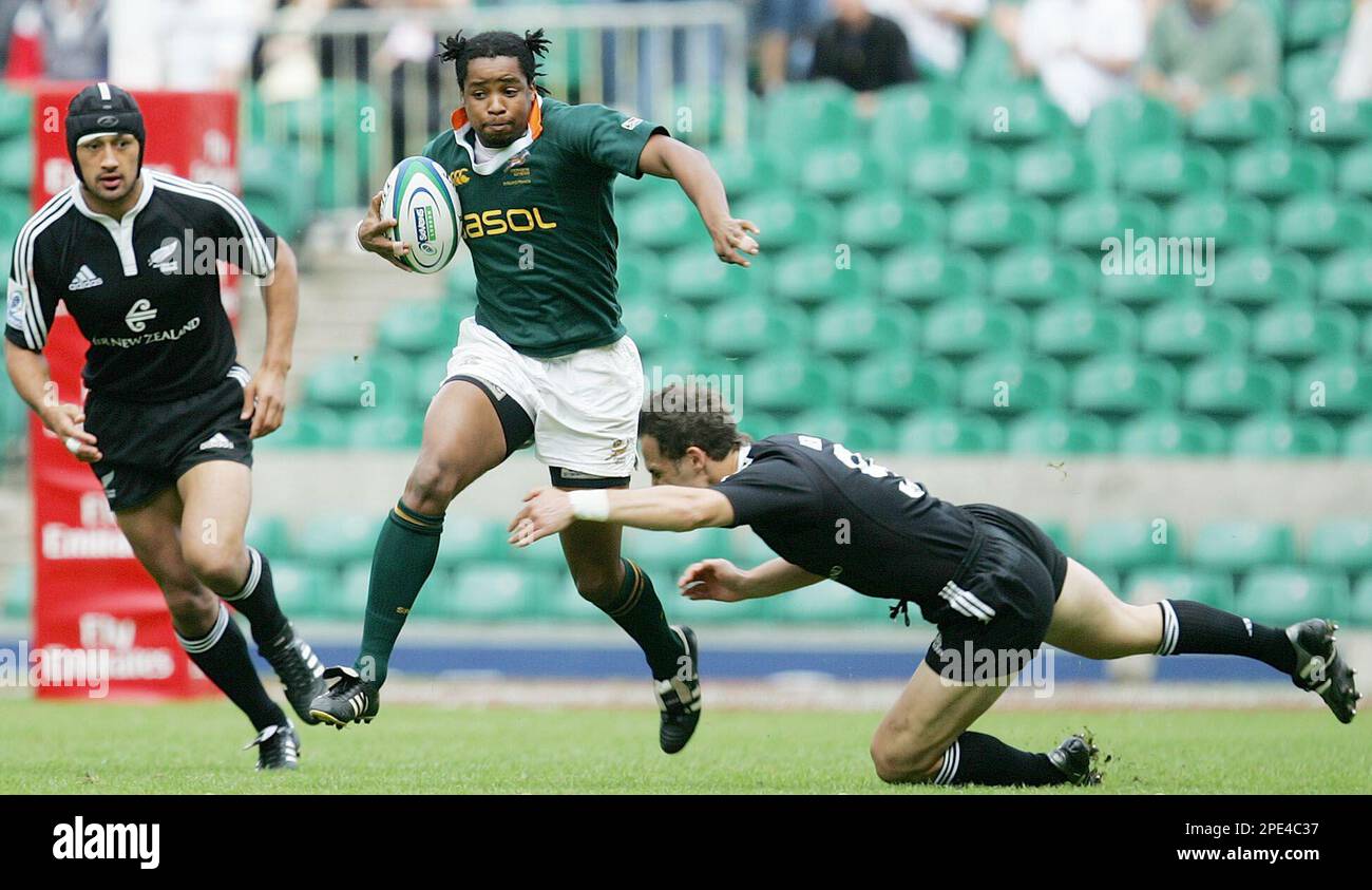 South Africa's Tobela Mdaka, centre, evades a tackle by New Zealand's ...