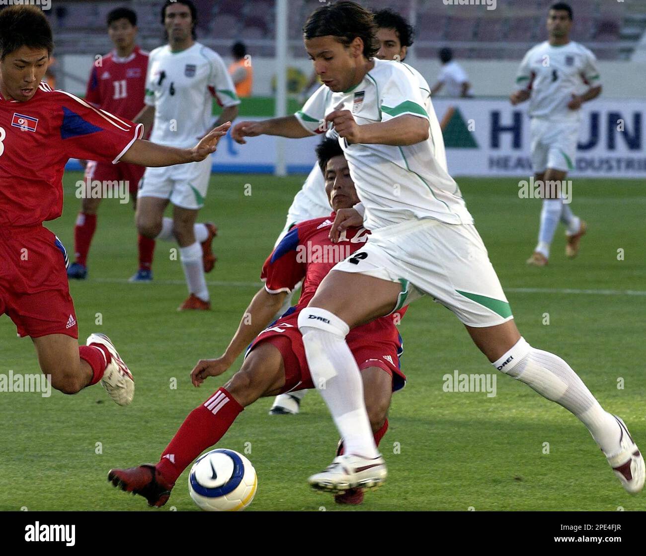 Iranian Fereydoon Zandi, right, kicks the ball as North Korea's Yong ...