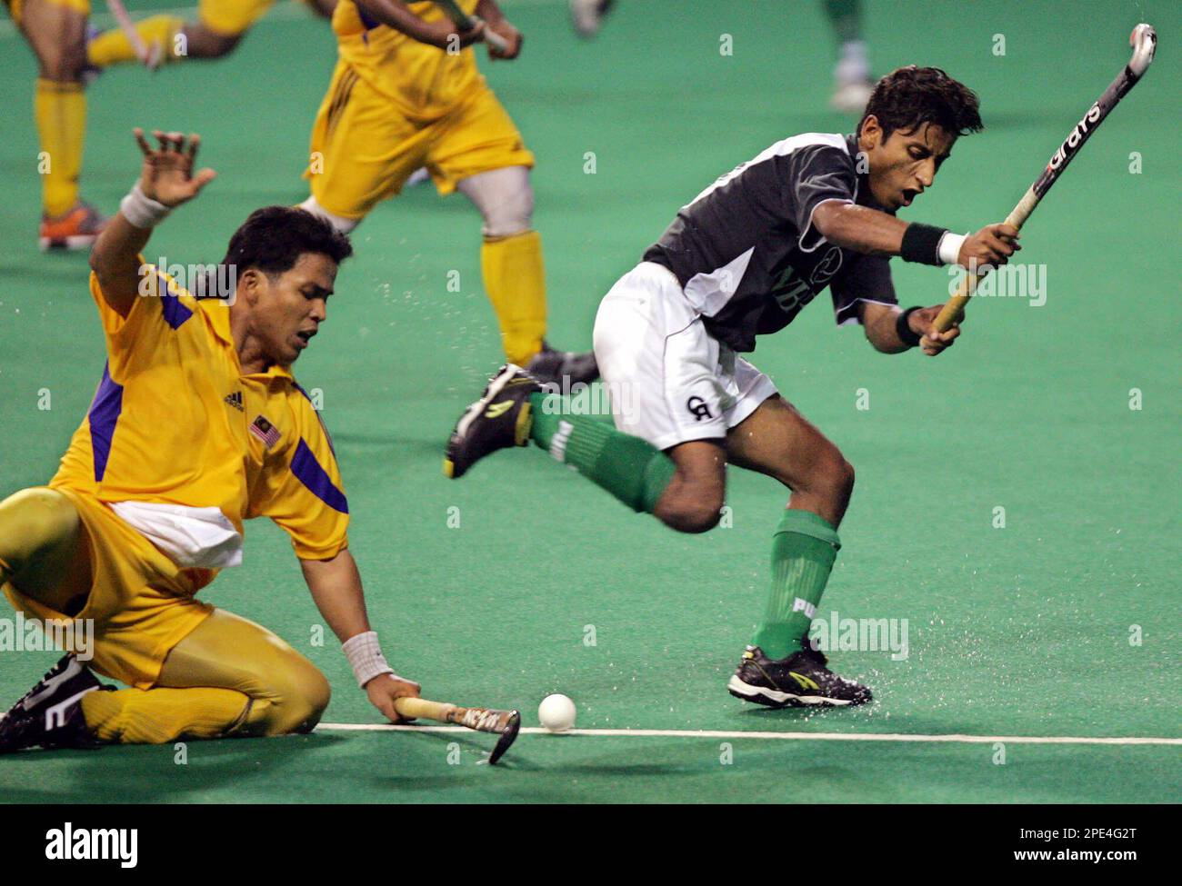 Malaysia's Muhamad Amin Rahim, left, manages to stop Pakistan's Adnan ...