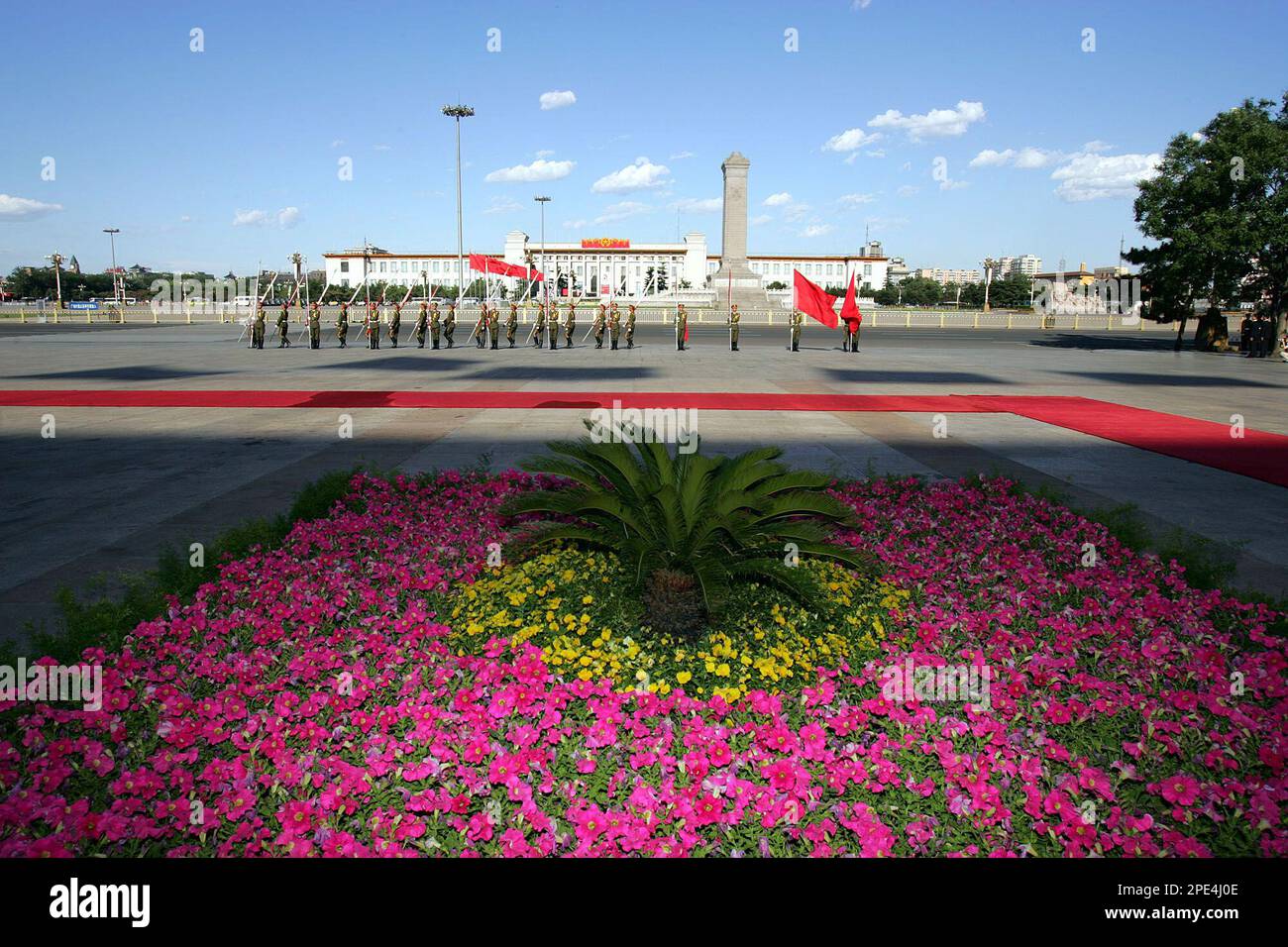 A pink flower bed lies near the place where Chinese soldiers march next ...