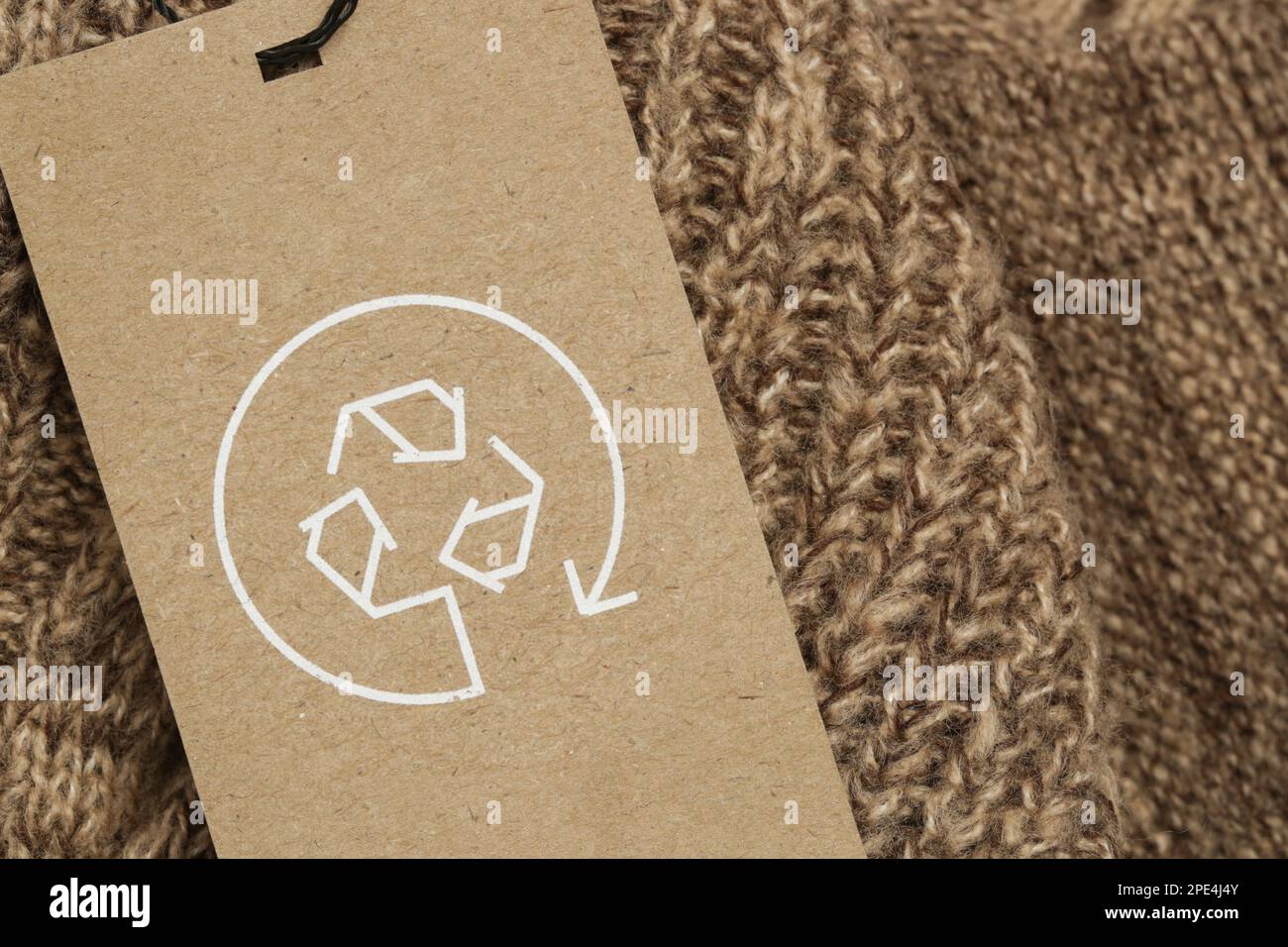 Close up of clothing tag with recycle icon. Recycling products concept ...