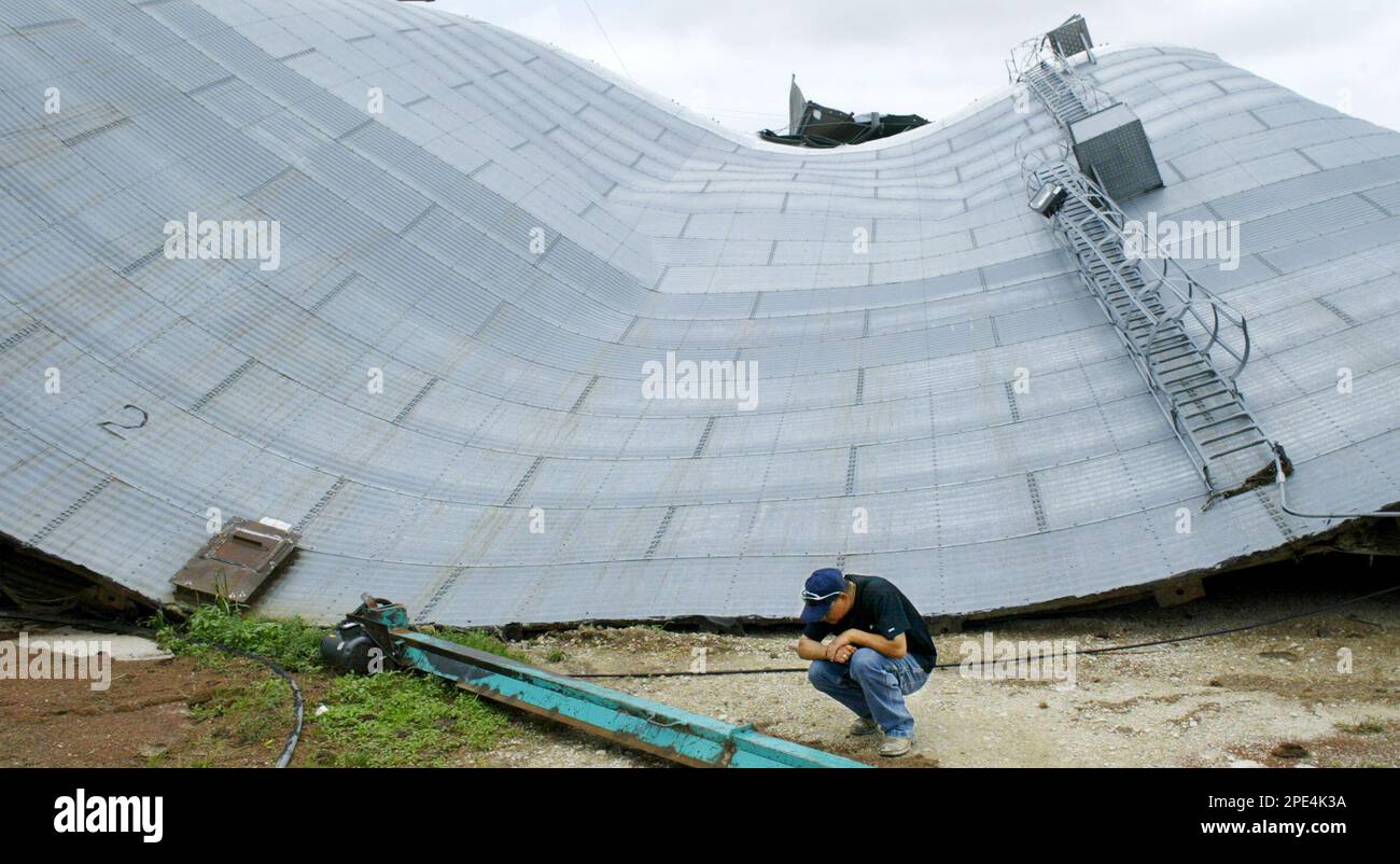 Employee Mario Torres looks at tornado damage to a grain auger near San ...