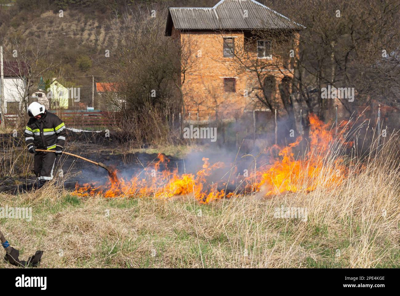 spring fire, burning dry grass near buildings in the countryside ...