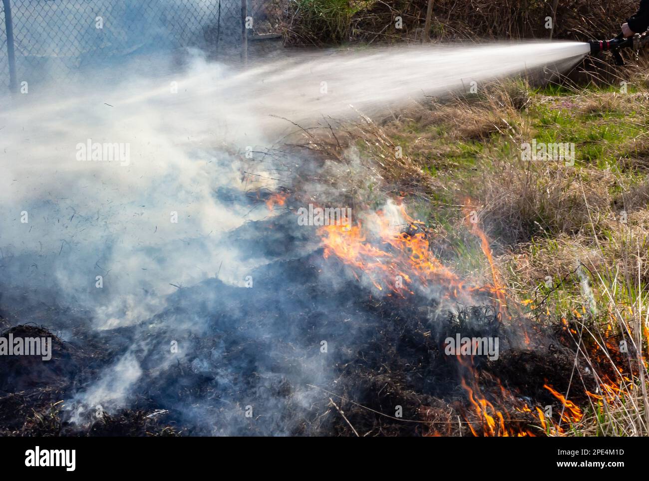 spring fire, burning dry grass near buildings in the countryside ...