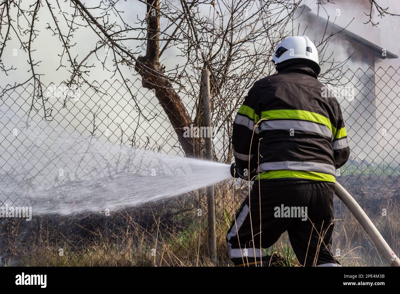 spring fire, burning dry grass near buildings in the countryside ...