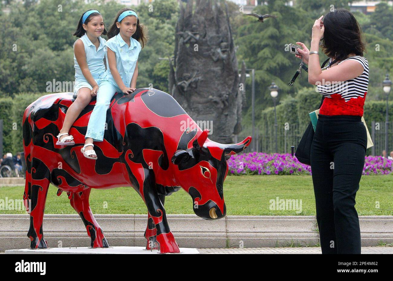 Two young girls pose for a snapshot as they play with one sculpture of ...