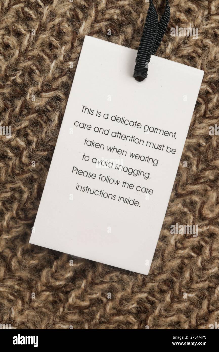 Close up of luxury clothing hang tag. Delicate garment swing tag ...