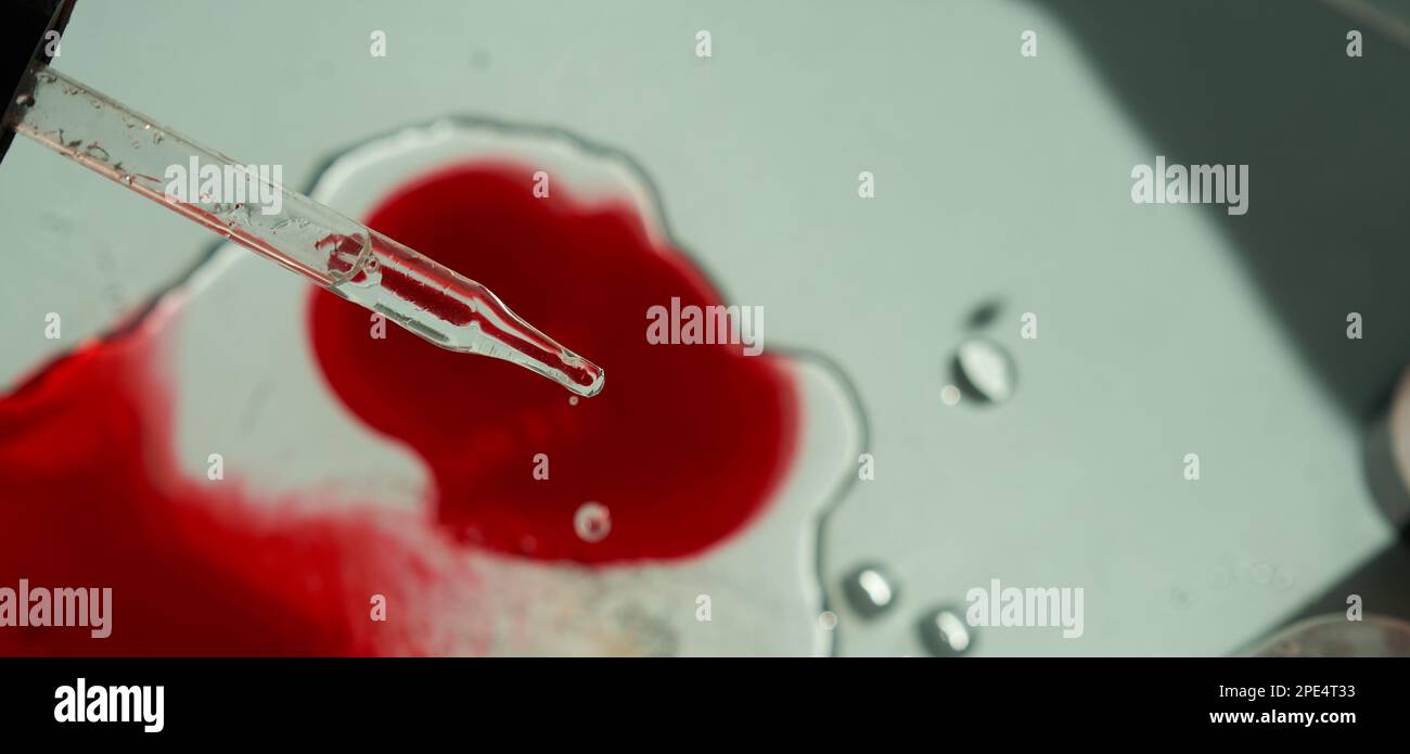 Red liquid with a pipette in the form of a spot in the container ...