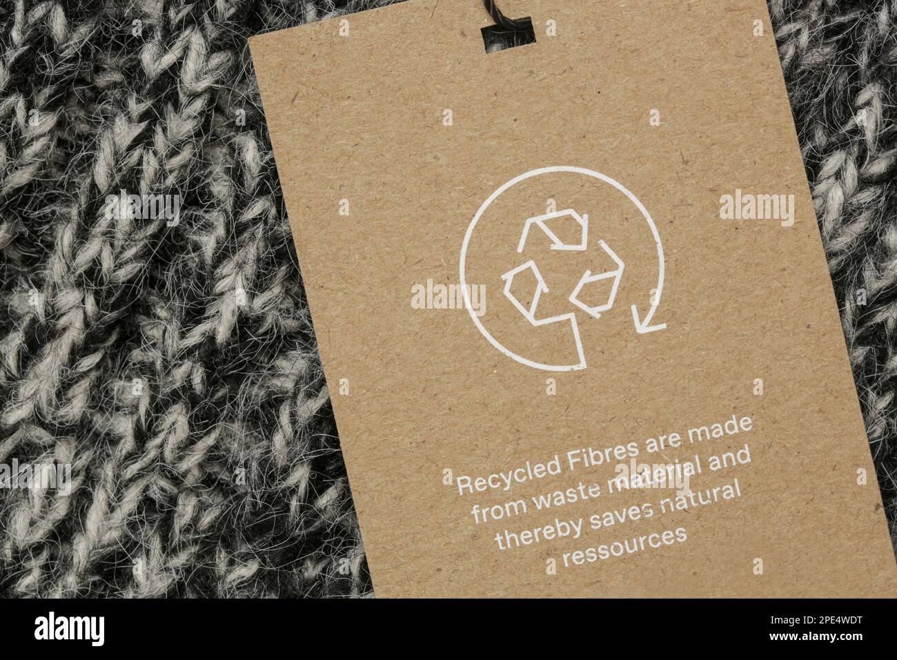 Close up of clothing tag with recycle icon. Recycling products concept ...