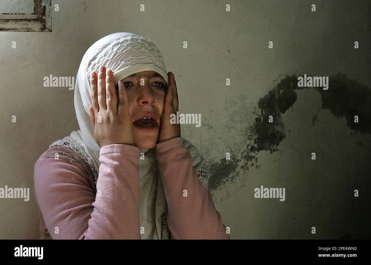 Fida, a niece of Palestinian Omar Mahmoud Hoshiya weeps during his ...