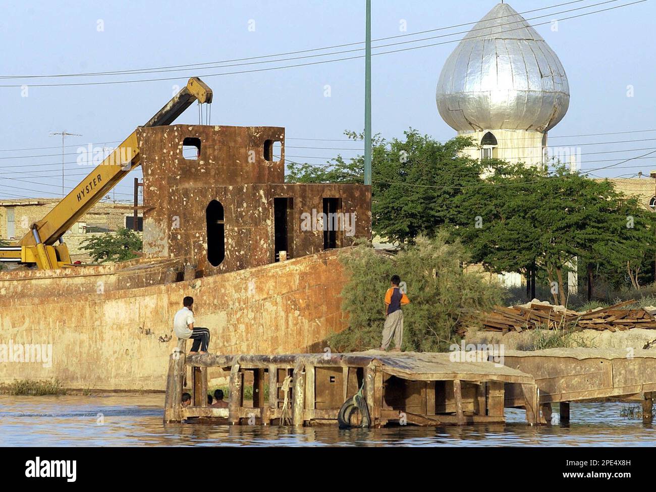 Two Iranian children look a the reamins of a ship that was damaged ...