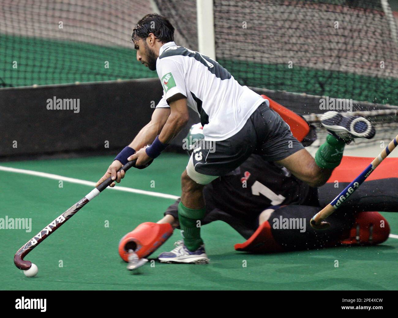 Pakistan's Shakeel Abbasi, foreground, keeps the ball past South Africa's goalkeeper Chris ...