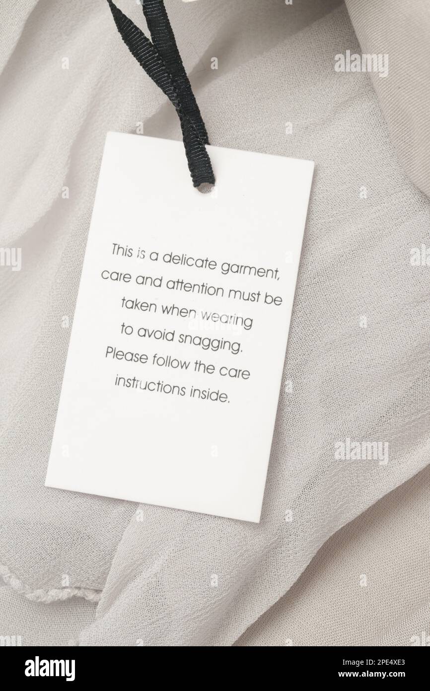 Close up of luxury clothing hang tag. Delicate garment swing tag ...