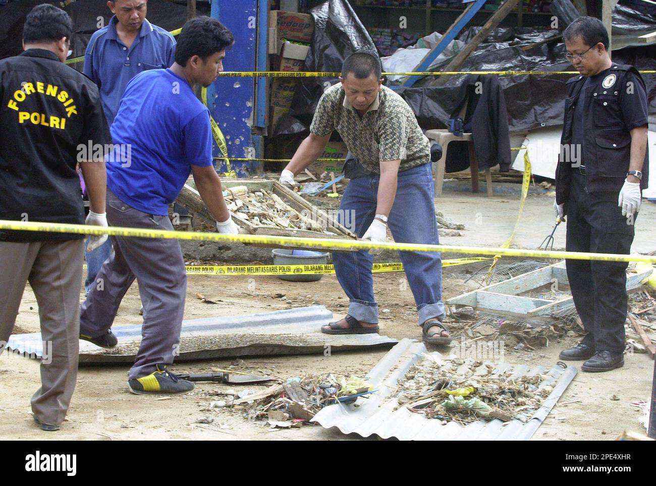 Indonesia's police forensic team members sift through the rubbles at ...