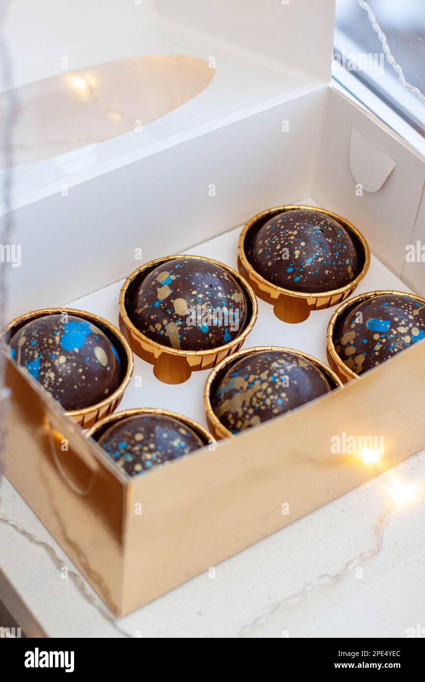 Chocolate spheres in golden gift box with burning candle Stock Photo ...