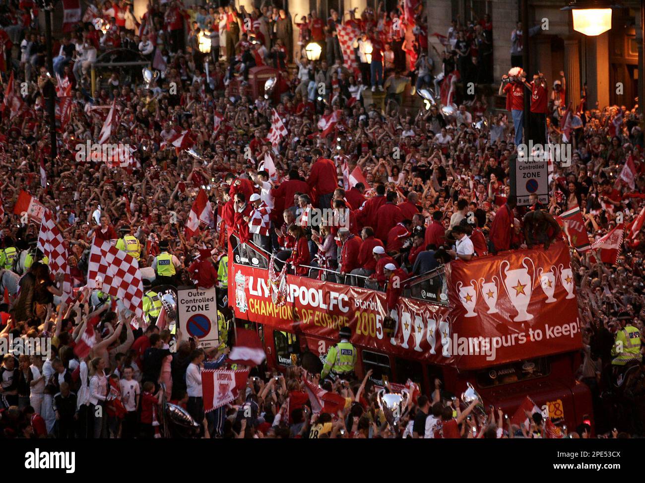 Surrounded by thousands offans, Liverpool players atop a bus celebrate ...
