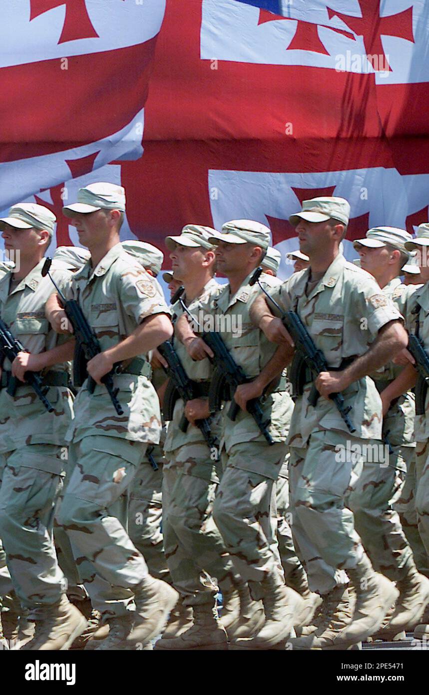 Georgian soldiers march, with Georgian flag in the background, during a ...