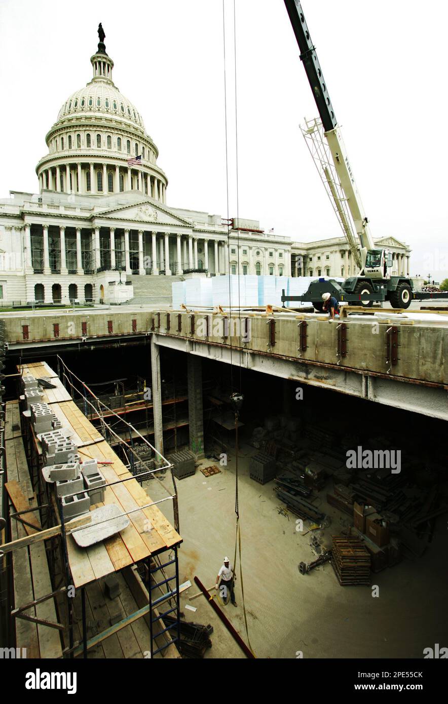 Worker Robert Crites, top right, standing on the ground level, assists ...