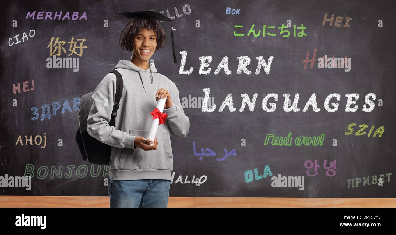 African american male student holding a diploma and posing in front of ...