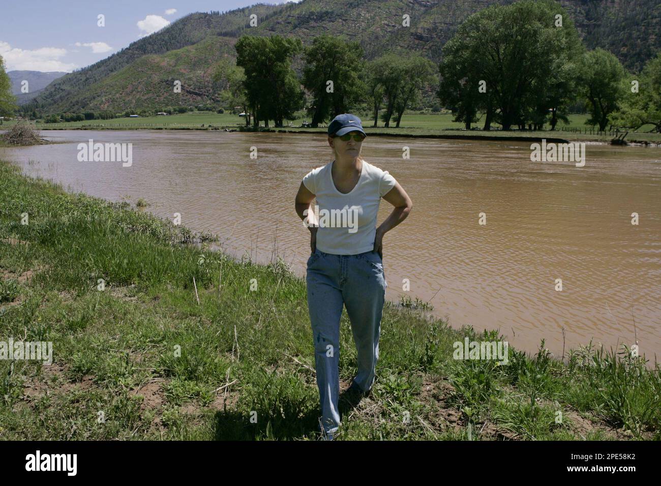 Jill Peters walks the bank of the swollen Animas River on her property ...