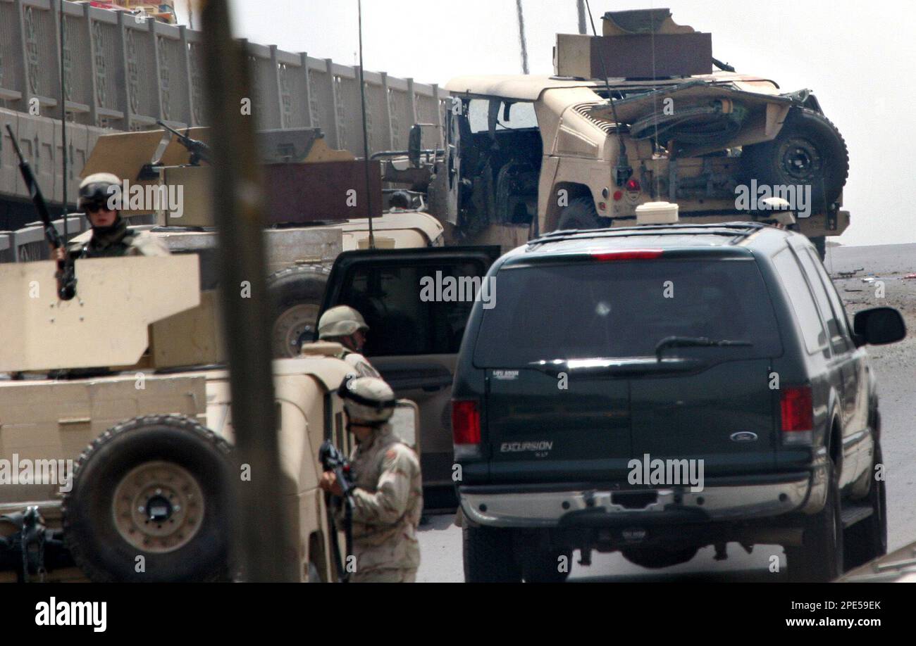 U.S. forces secure the area around a damaged Humvee, top-right, after a ...