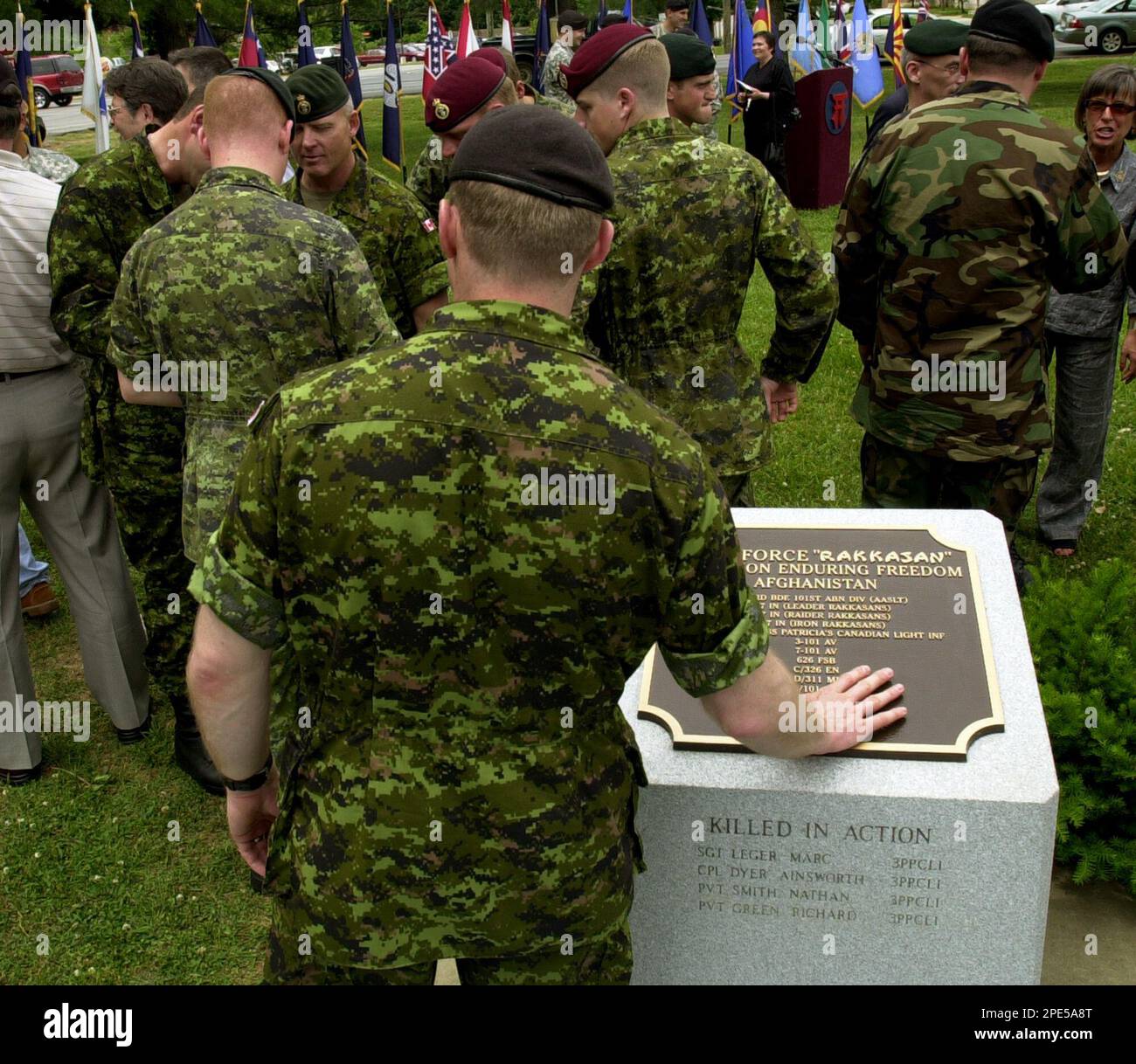 Canadian soldier Capt. Todd McClure, center, places his hand on a ...