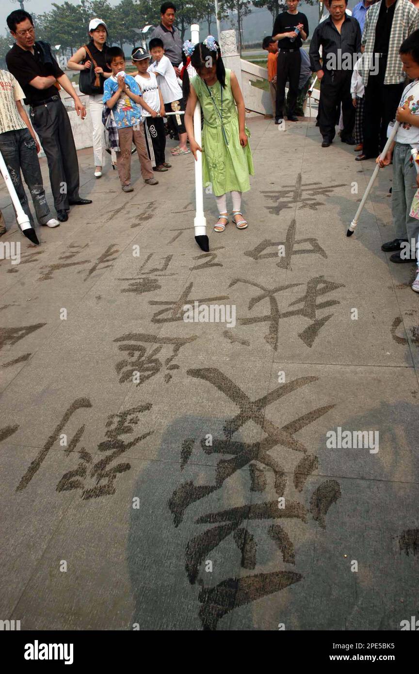 A girl writes on the ground during a ground calligraphy contest in ...