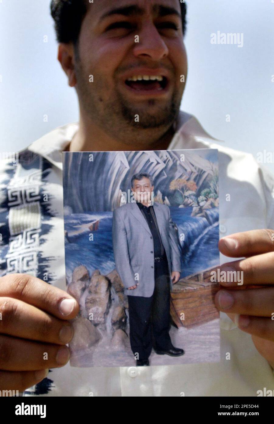 Son Hussein Ali Moussa holds a photograph of his father Ali Moussa, the ...