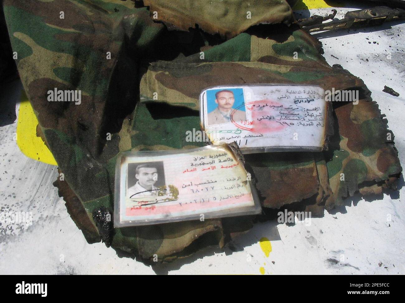 Charred ID cards and clothing rest on a vehicle, after a 20-vehicle ...