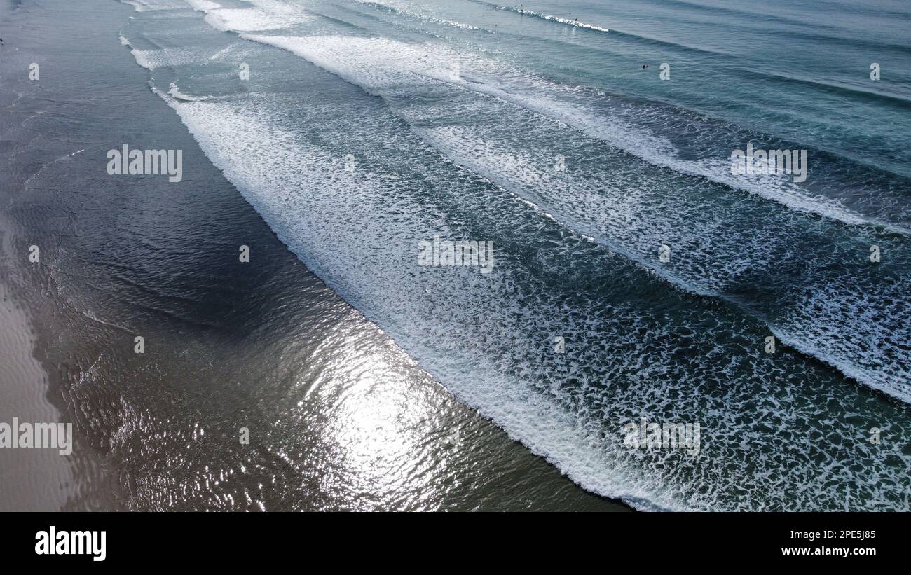 Aerial view of ocean waves rolling onto beach shoreline Stock Photo - Alamy