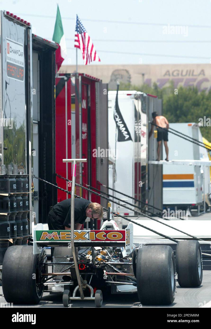 An engineer works on Mexican racer Jorge Goeter's car, during the Champ ...