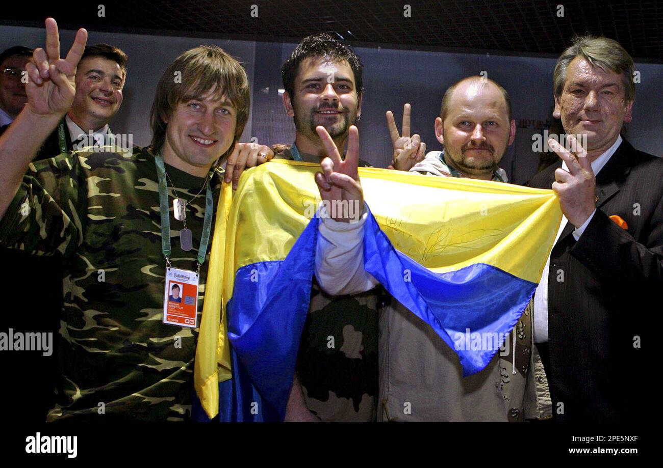 Ukrainian President Viktor Yushchenko, right, shows a V-sign, and holds ...