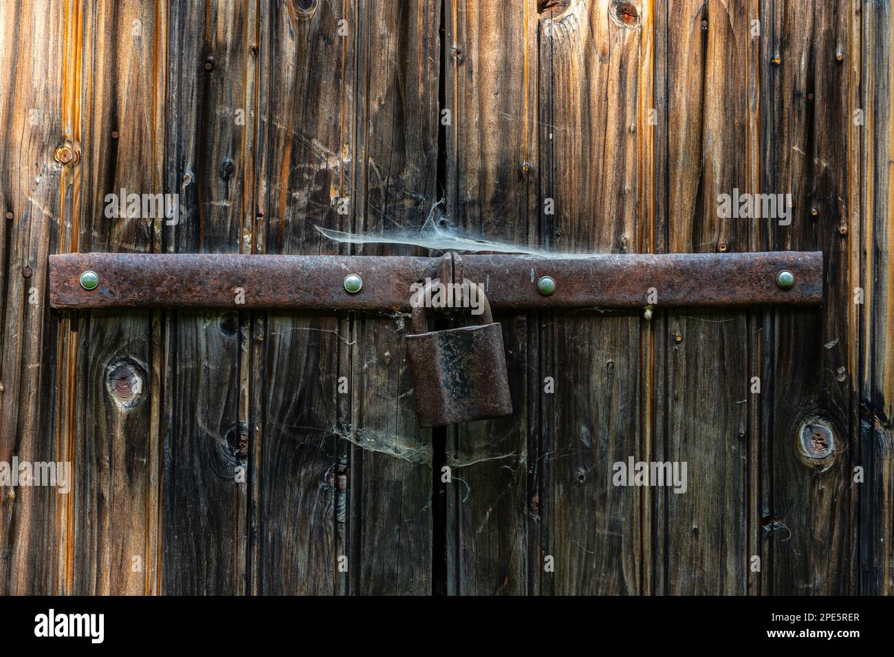 Close up view of the old rusty padlock on a aged gray wooden door Stock ...