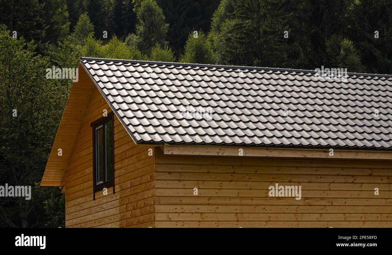 roof covered with metal tiles, roofing, wooden house Stock Photo - Alamy