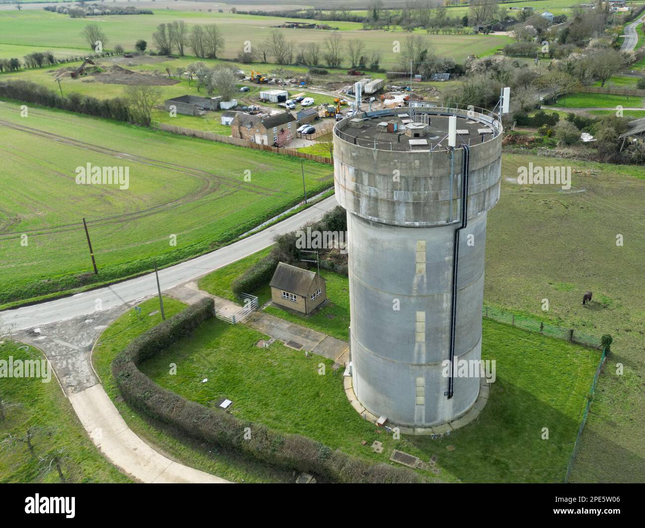 Drone view of a concrete water tower which has an array of 5G antennas ...