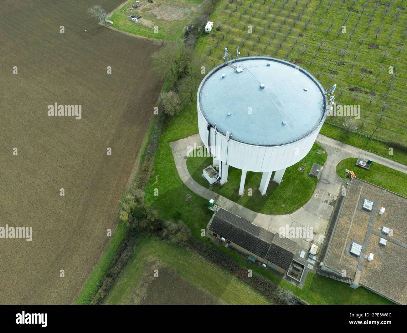 Aerial view of a large concrete water tower seen next to a large shed ...