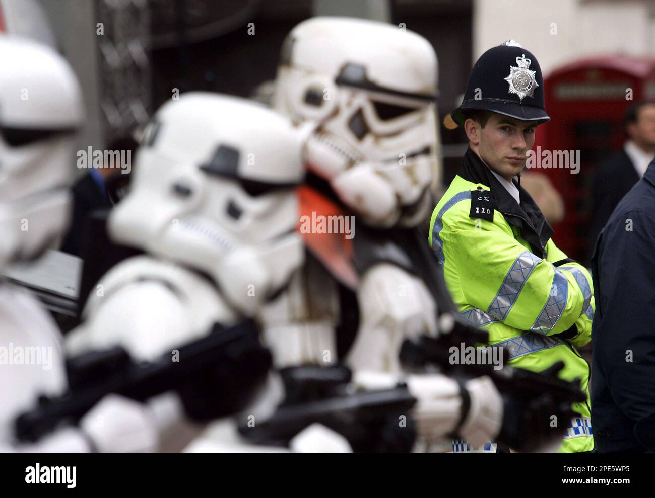 A British police officer looks on as stormtrooper characters from the ...