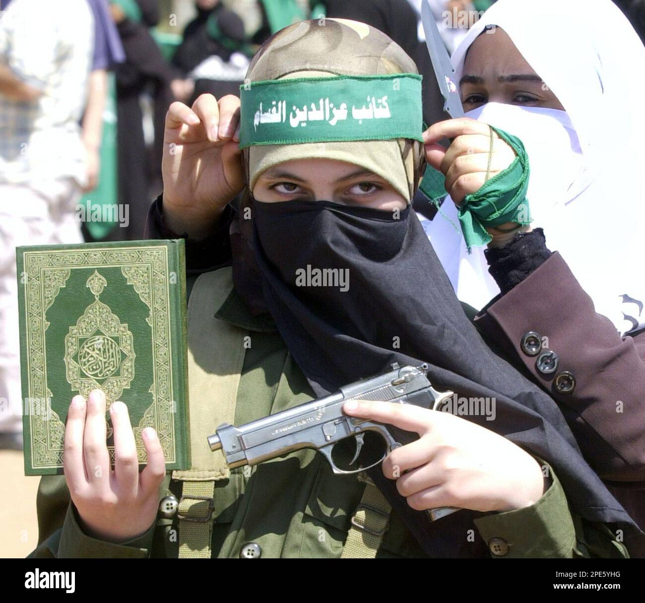 A women belonging to the Hamas militant group holds a toy gun and a ...