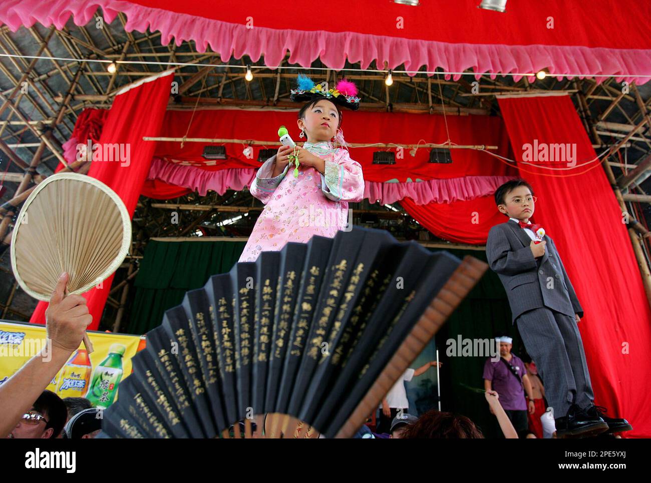 A girl dressed in a traditional Chinese costume is carried along in a ...