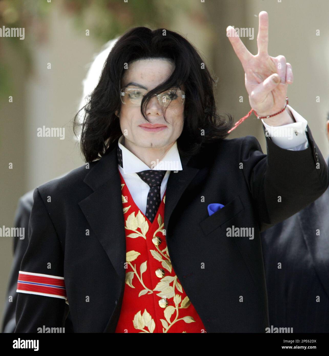 Michael Jackson flashes the V sign to cheering fans as he leaves after ...